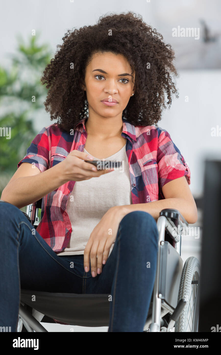 Disabled lady using remote control Stock Photo - Alamy