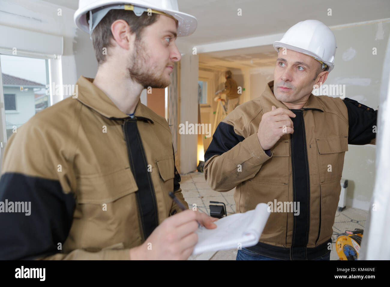 builders talking indoors Stock Photo - Alamy