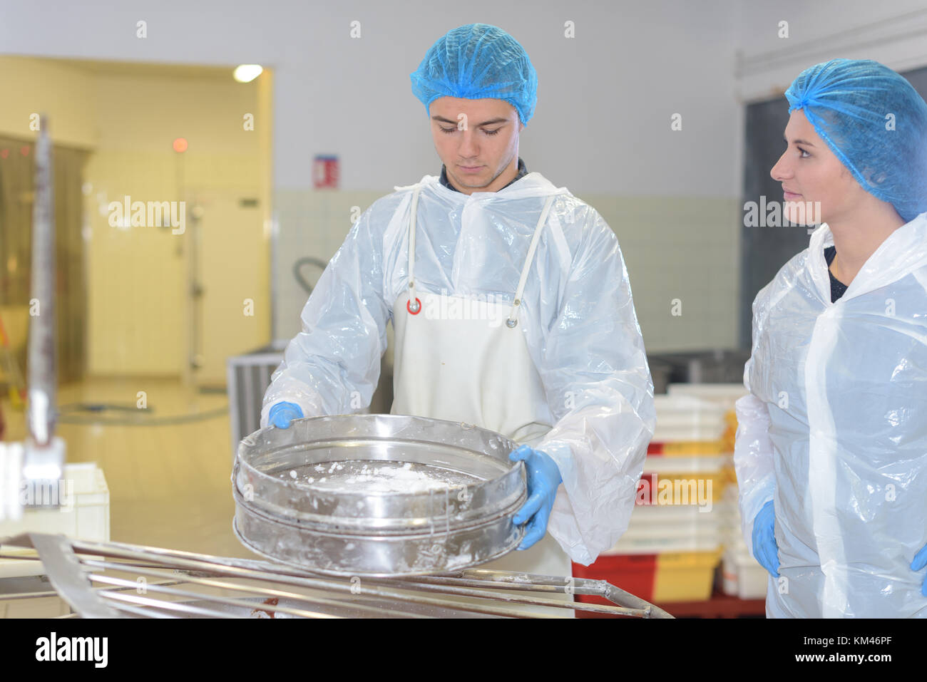 Factory operative using sieve Stock Photo - Alamy