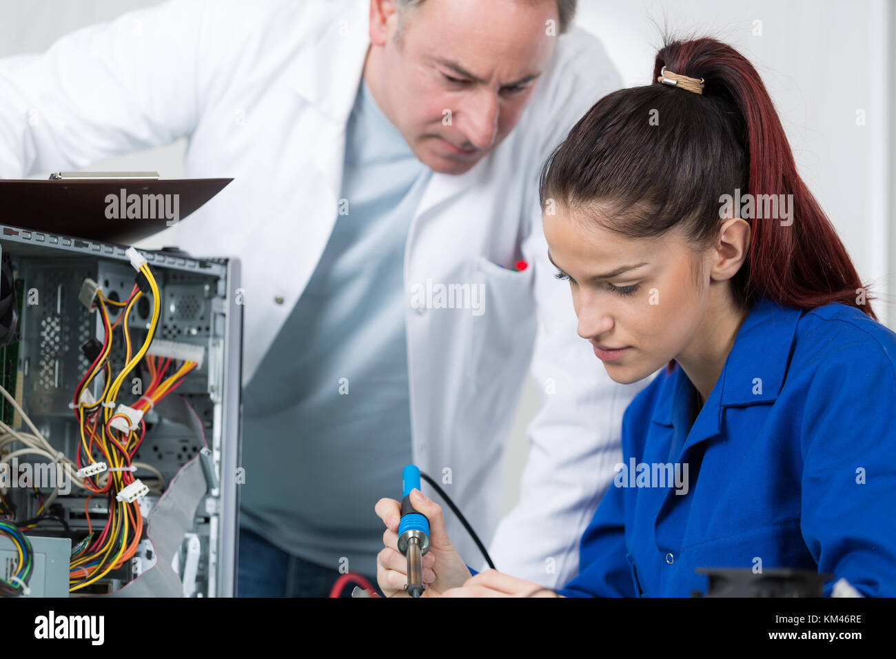 Young worker learning to use soldering iron Stock Photo - Alamy