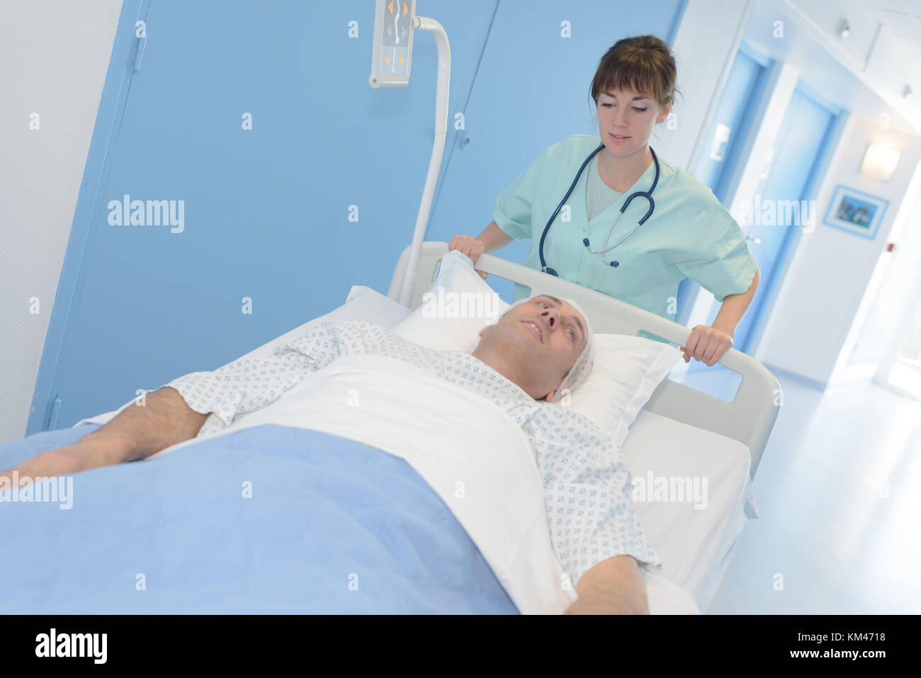 Nurse pushing patient in his bed Stock Photo - Alamy