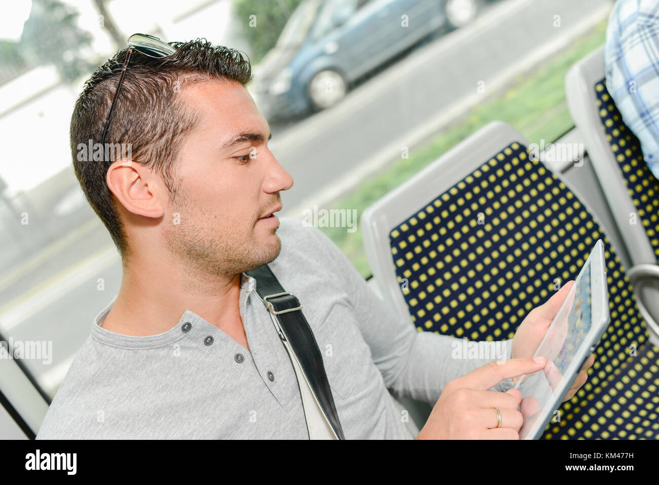 Using tablet computer during daily commute Stock Photo - Alamy