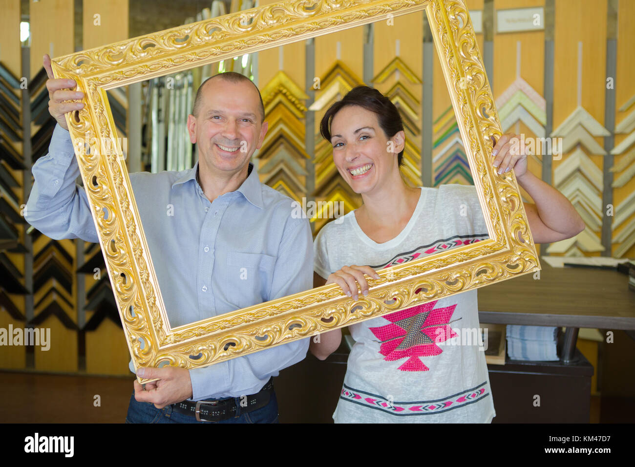 couple in a cute picture holding a wooden frame Stock Photo - Alamy
