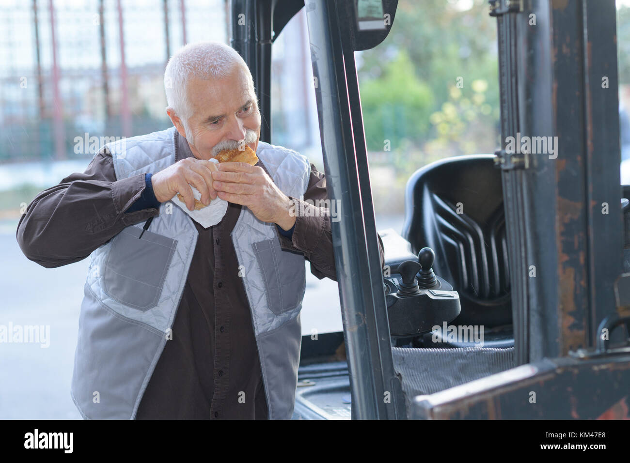 Fork lift driver eating a sandwich Stock Photo - Alamy