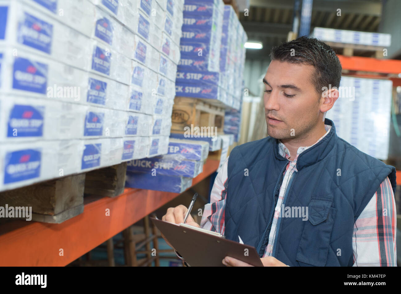 man checking list on clipboard in a warehouse Stock Photo - Alamy