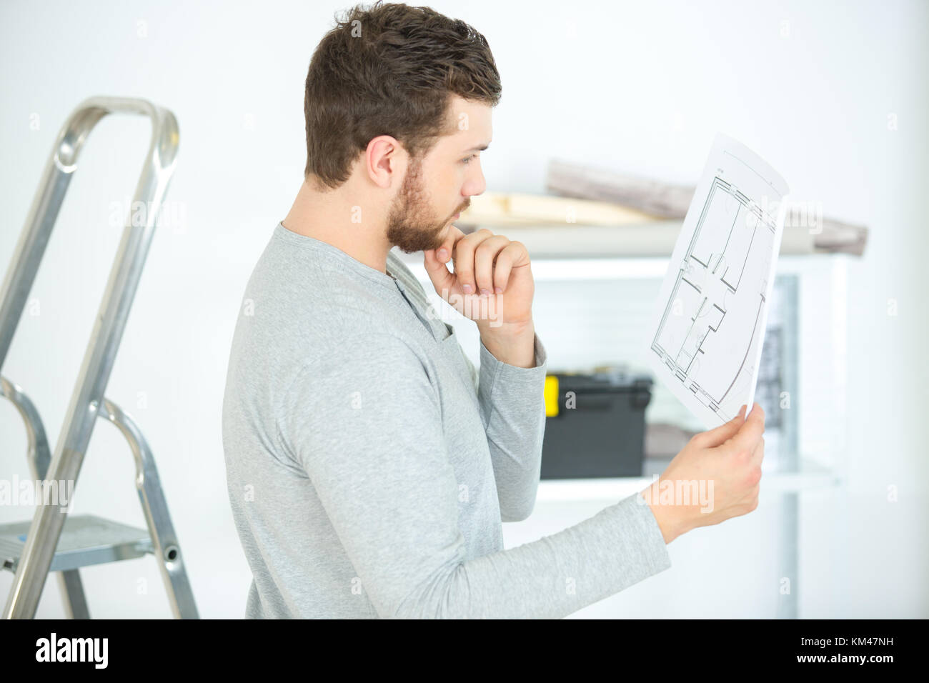 young male architect reading blueprint Stock Photo - Alamy
