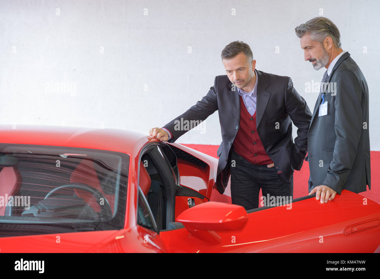 luxury car dealer showing lamborghini to client Stock Photo - Alamy