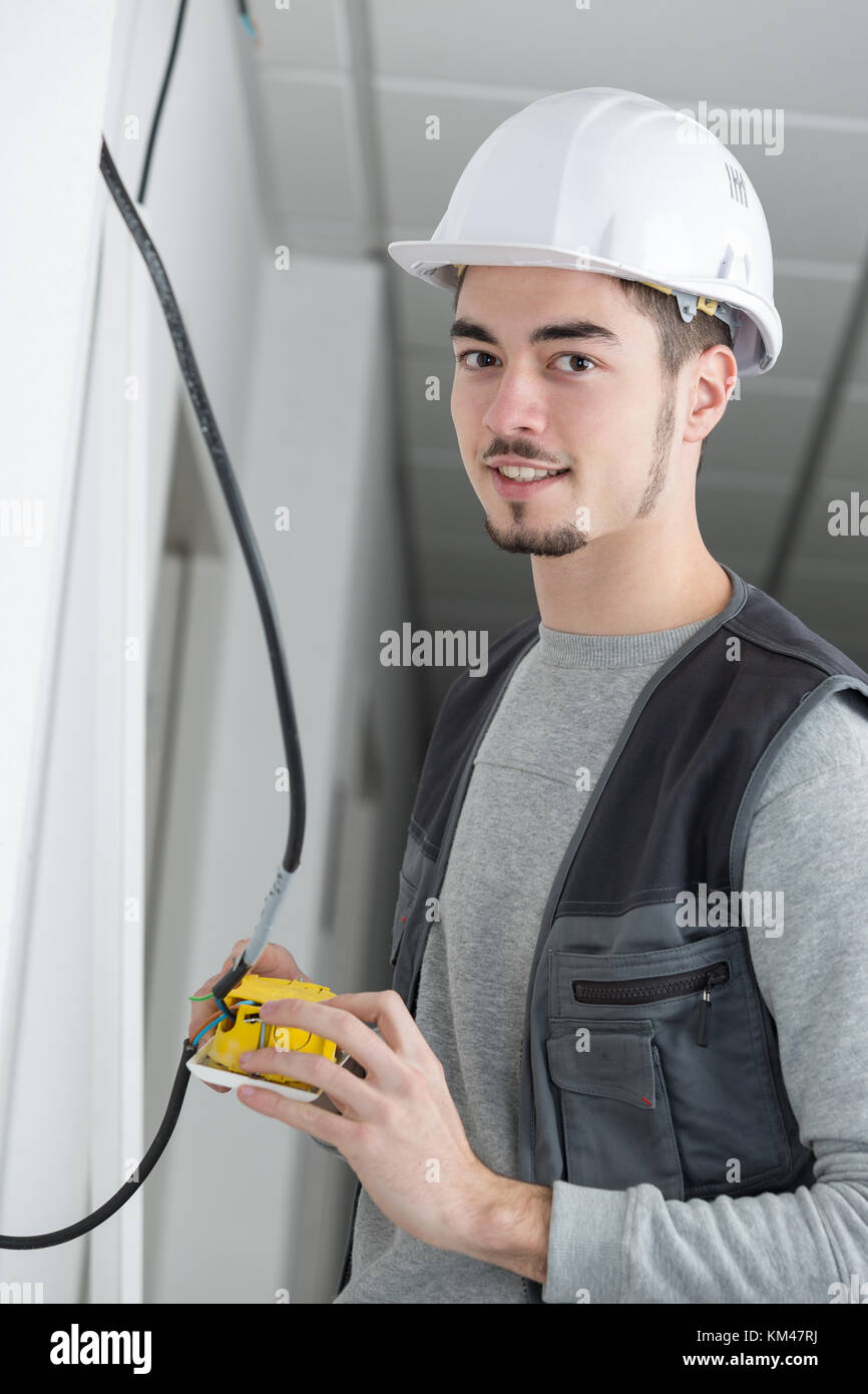 handsome young electrician working at construction site Stock Photo - Alamy