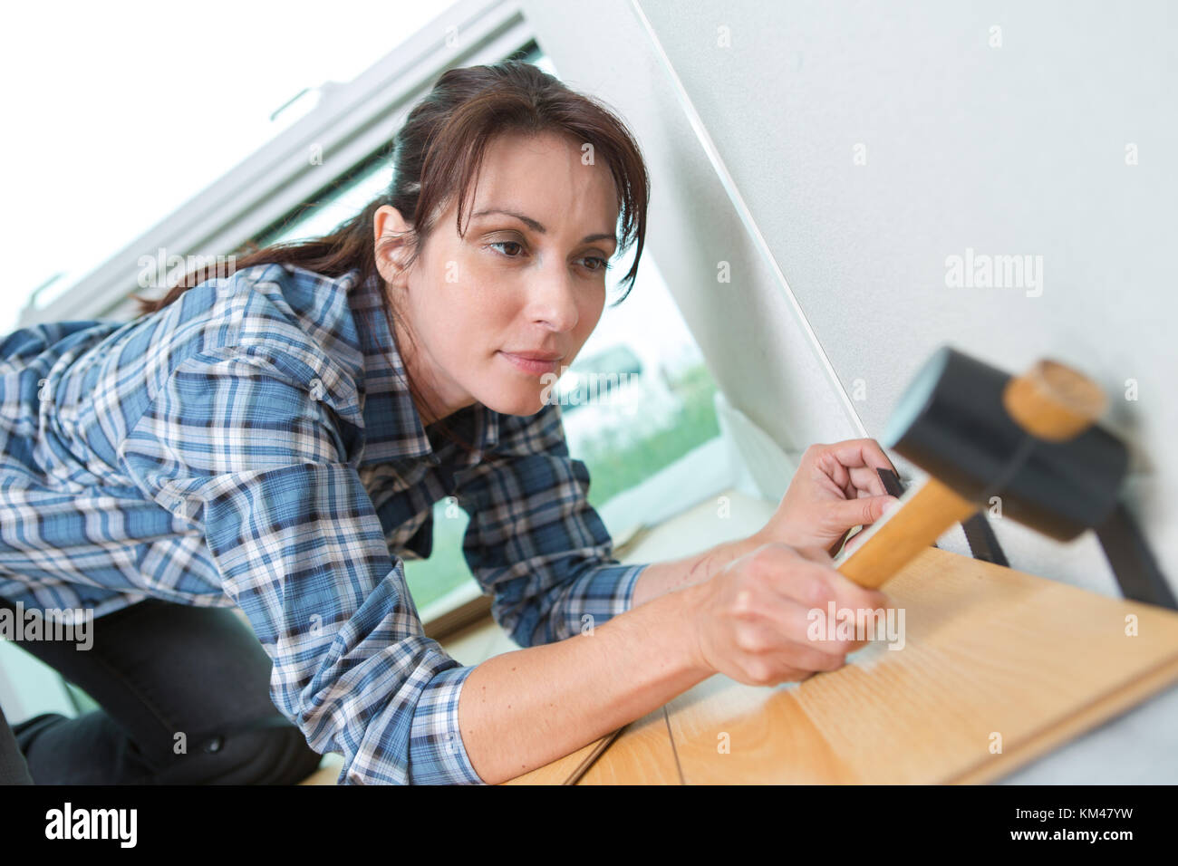 female nailing a plank at home Stock Photo - Alamy