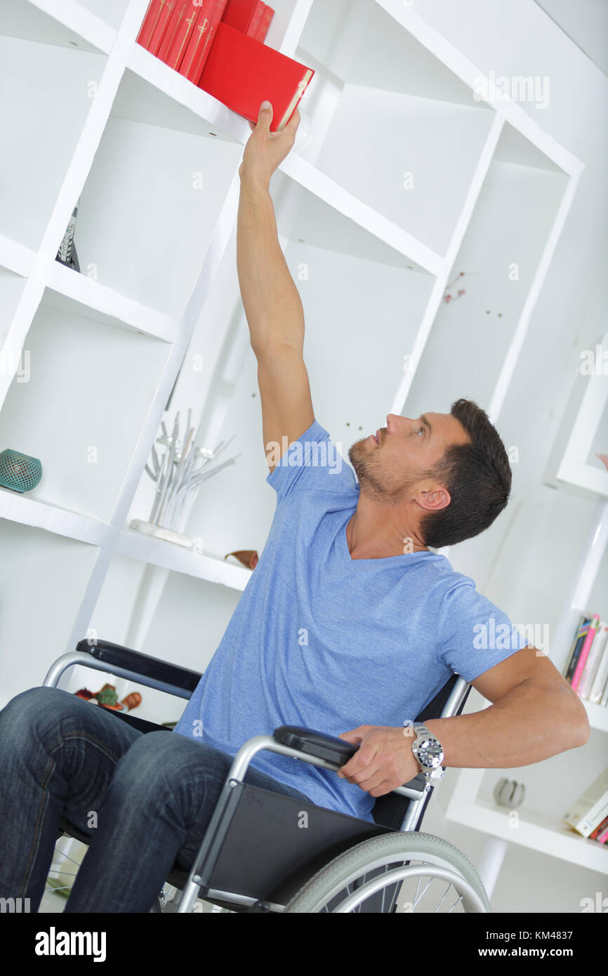 man on wheelchair during everyday task Stock Photo - Alamy
