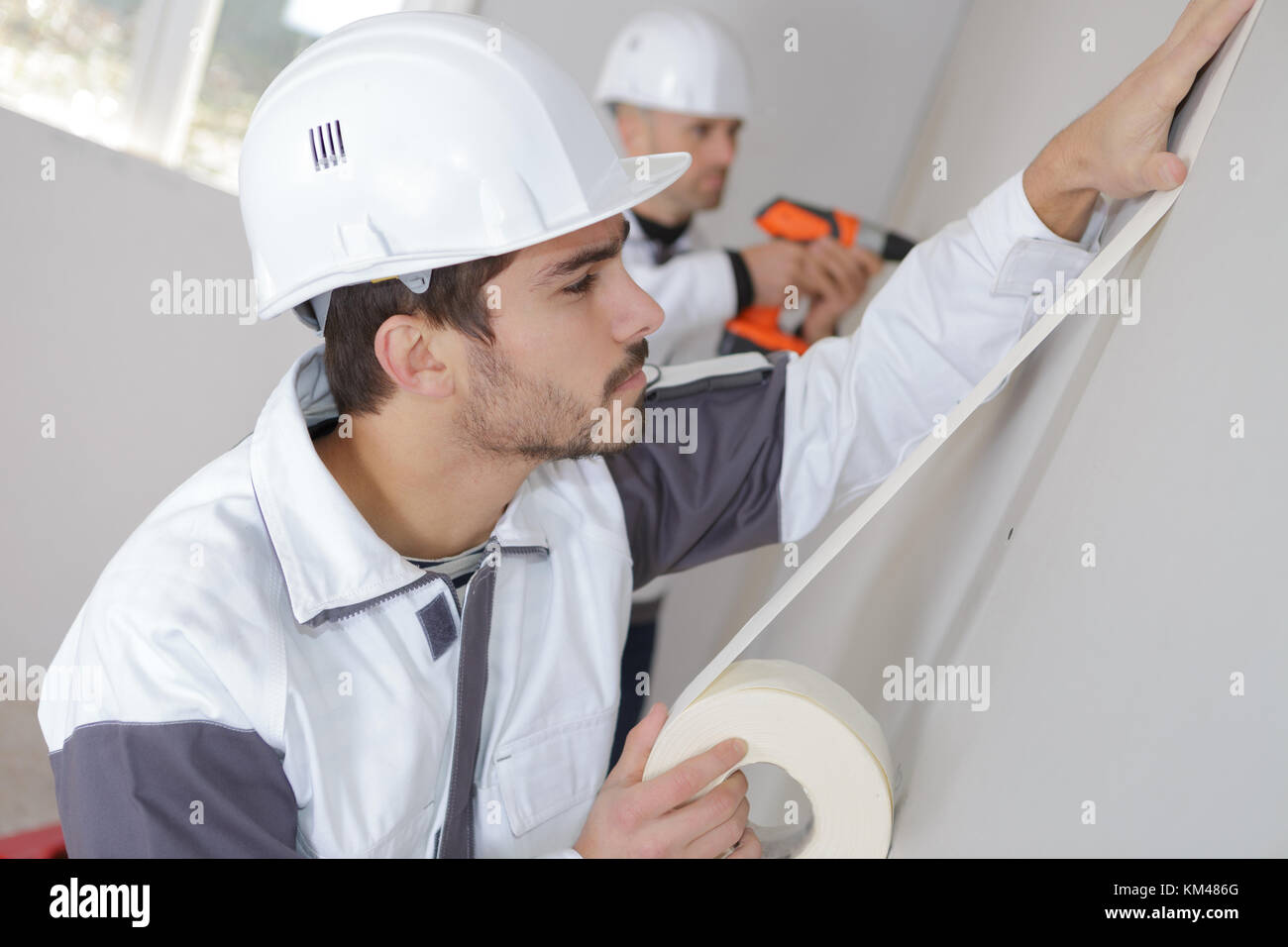 worker protecting wall with masking tape before painting Stock Photo ...