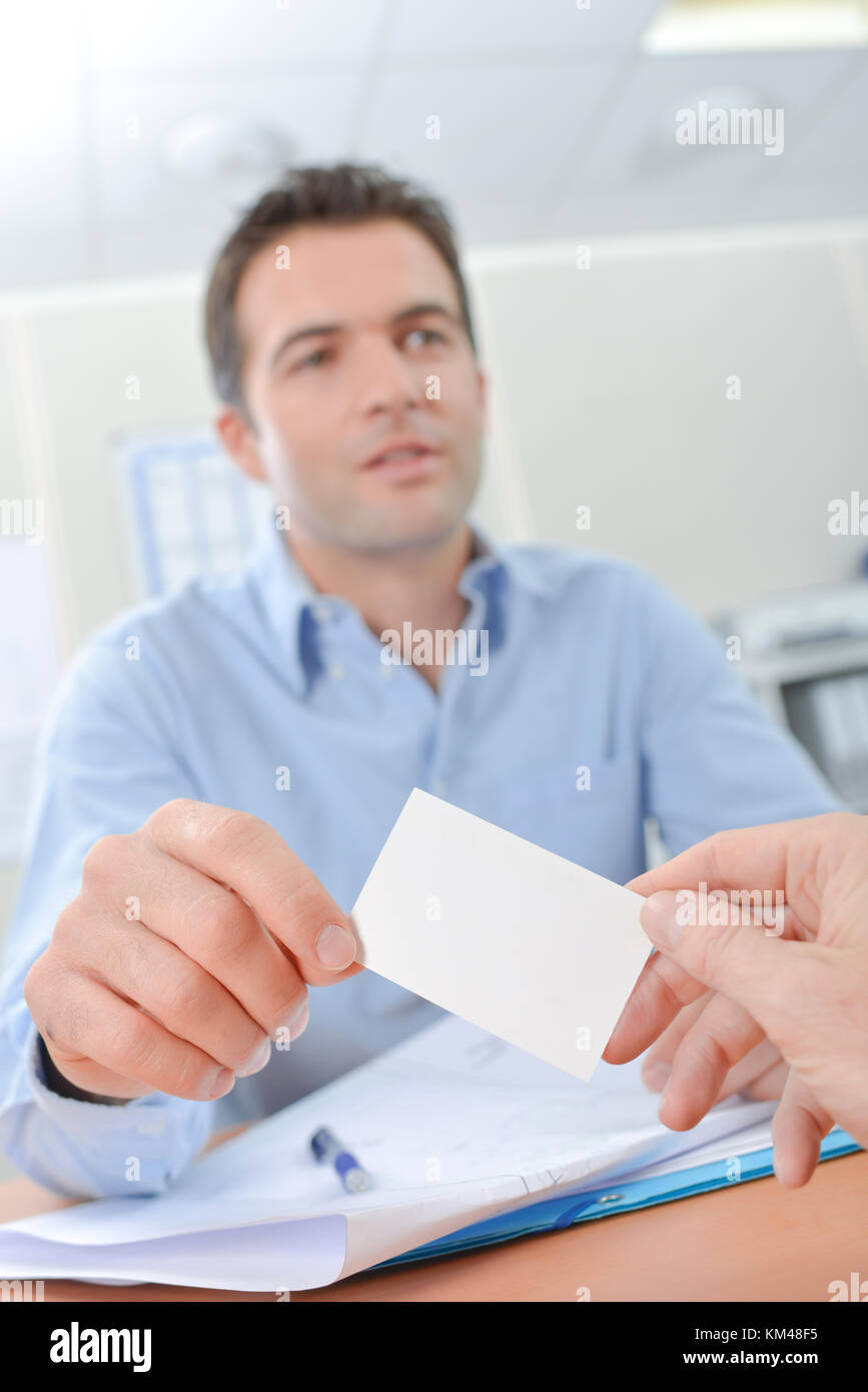 man giving card in office Stock Photo - Alamy