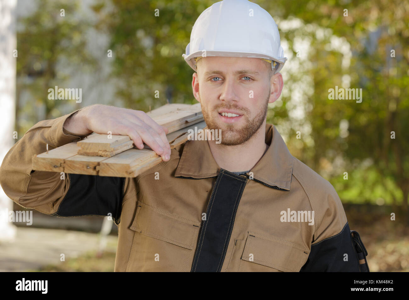 builder carrying wood Stock Photo - Alamy