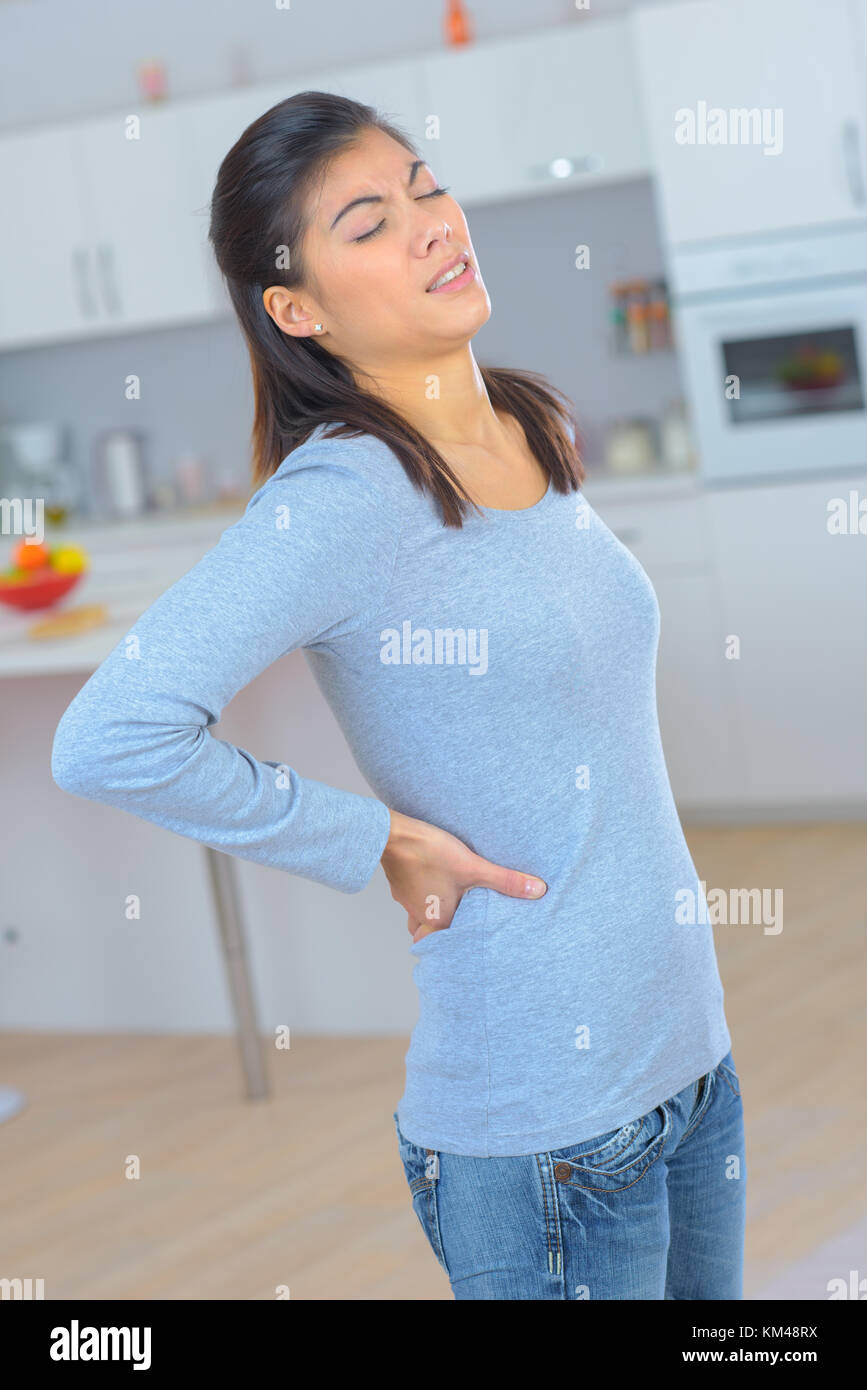 young woman has a backache at home Stock Photo - Alamy