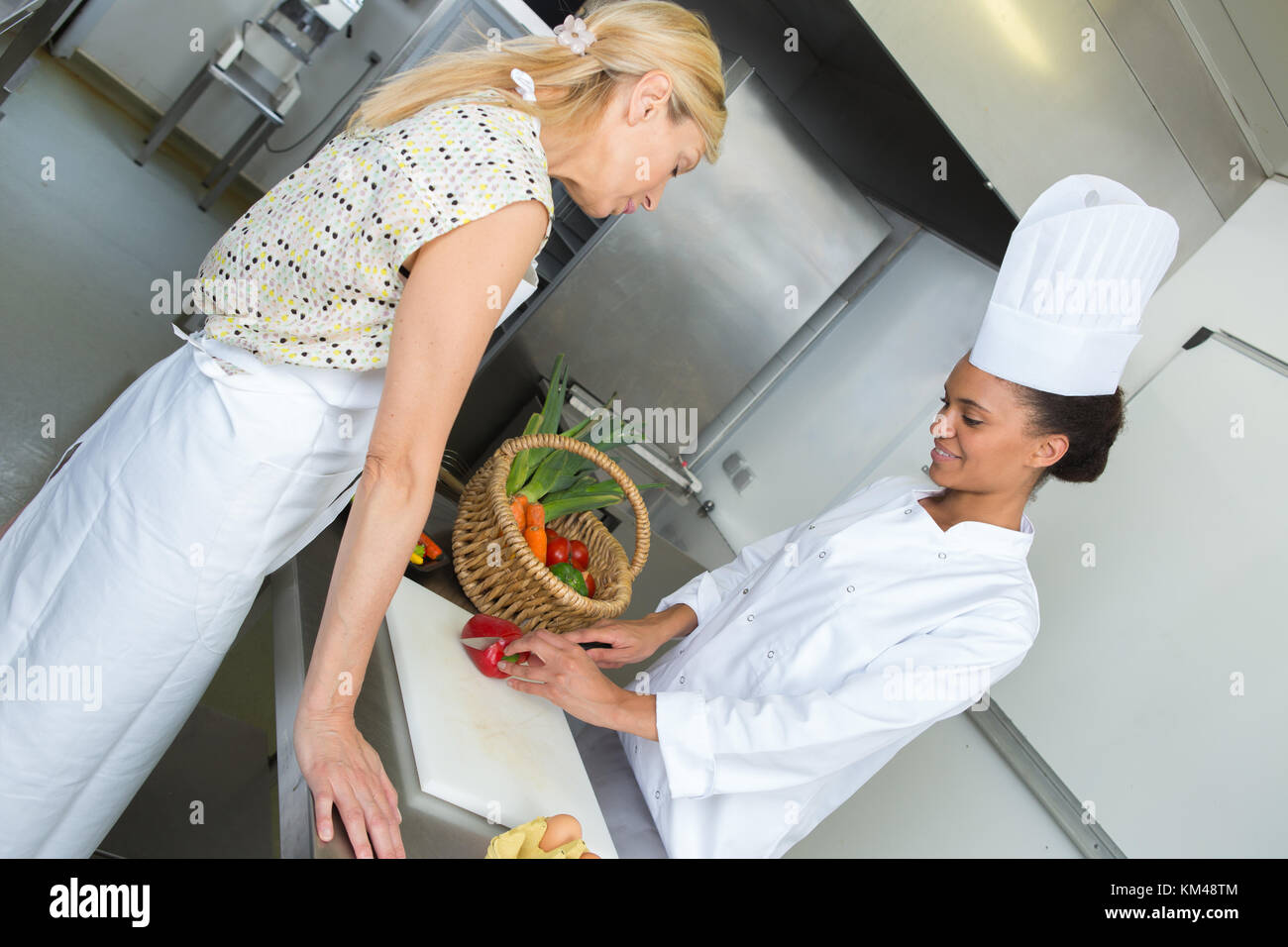 two female chefs working beside each other in hotel kitchen Stock Photo ...