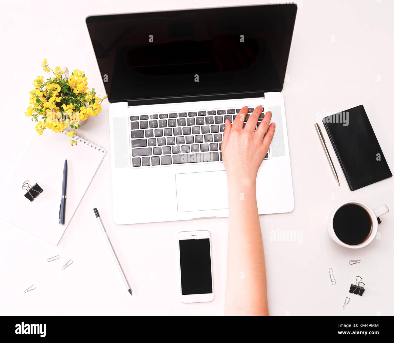 Workspace with woman hand on laptop keyboard, mobile phone, coffee ...