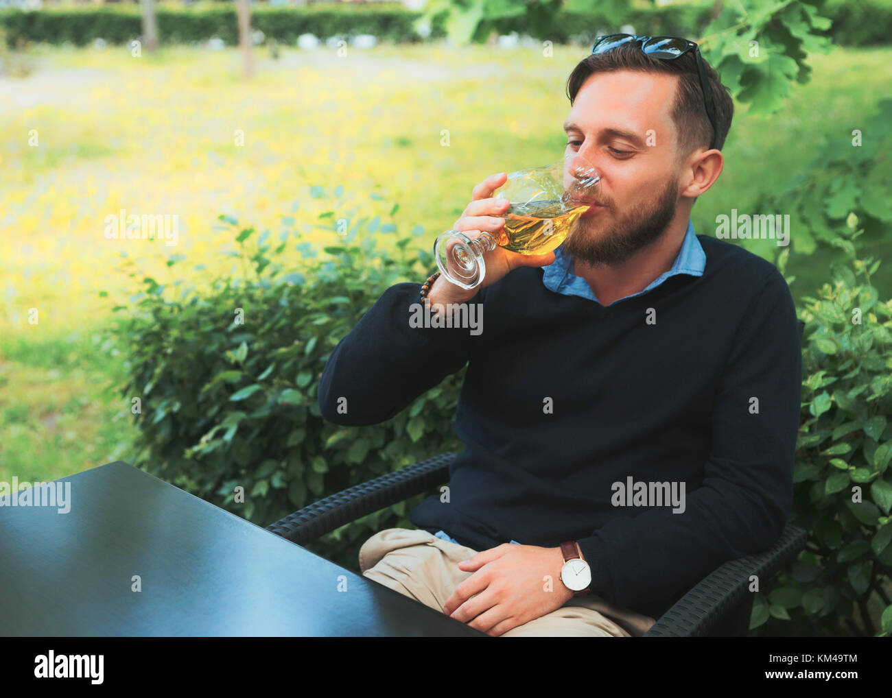 Young man drinking glass of beer in a street cafe Stock Photo - Alamy