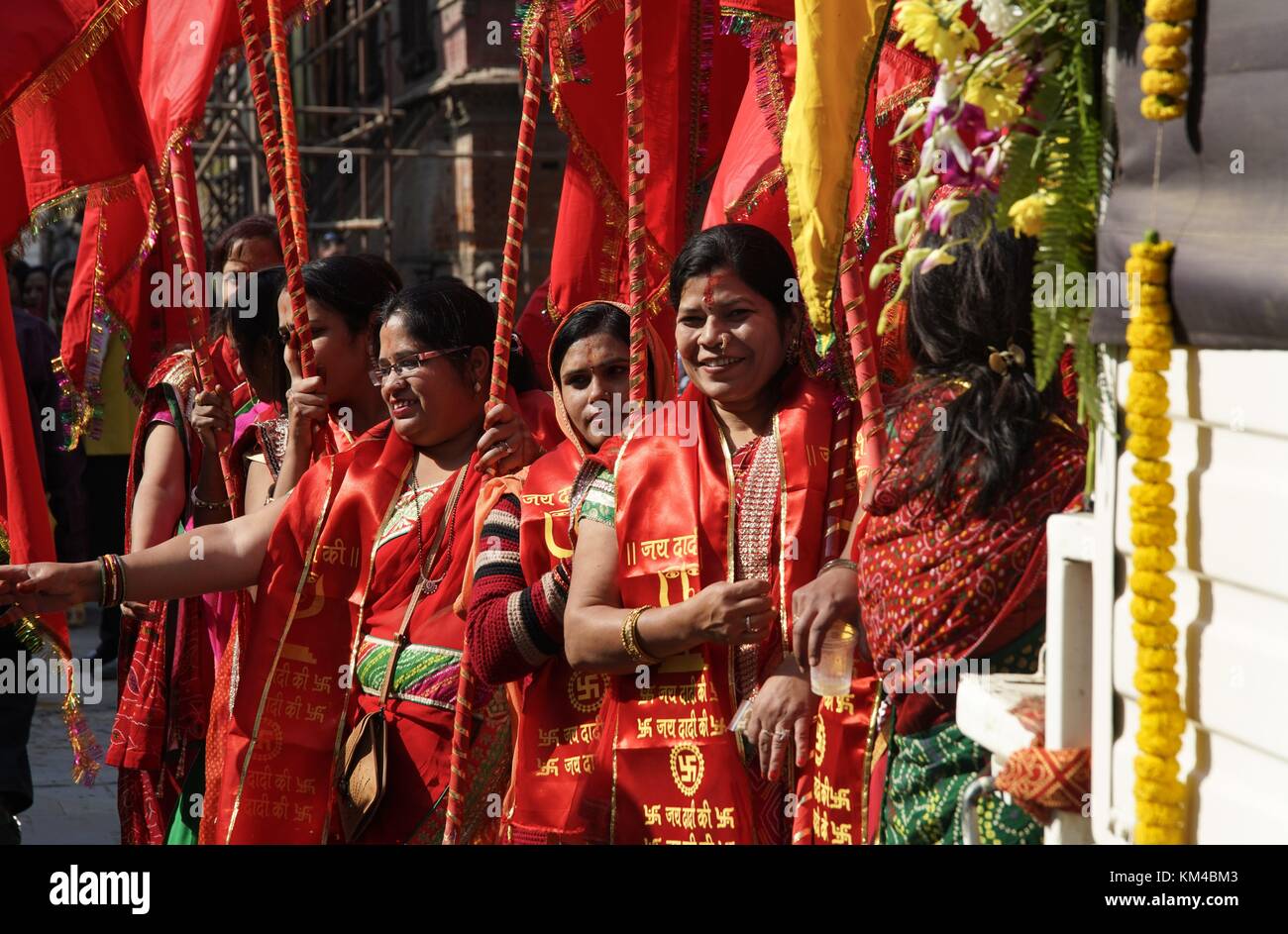 A procession with women dressed in red clothes passes the old royal ...