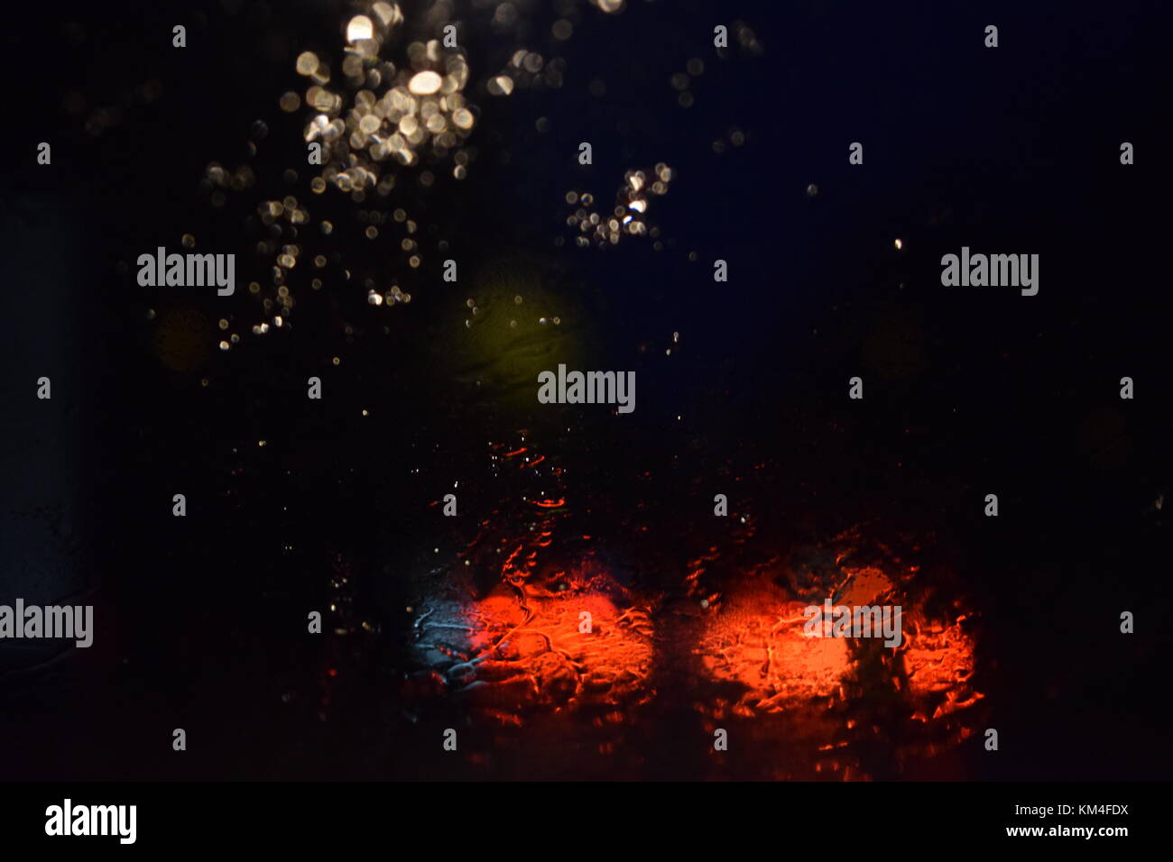 Street lights captured through a rain covered window with the focus ...