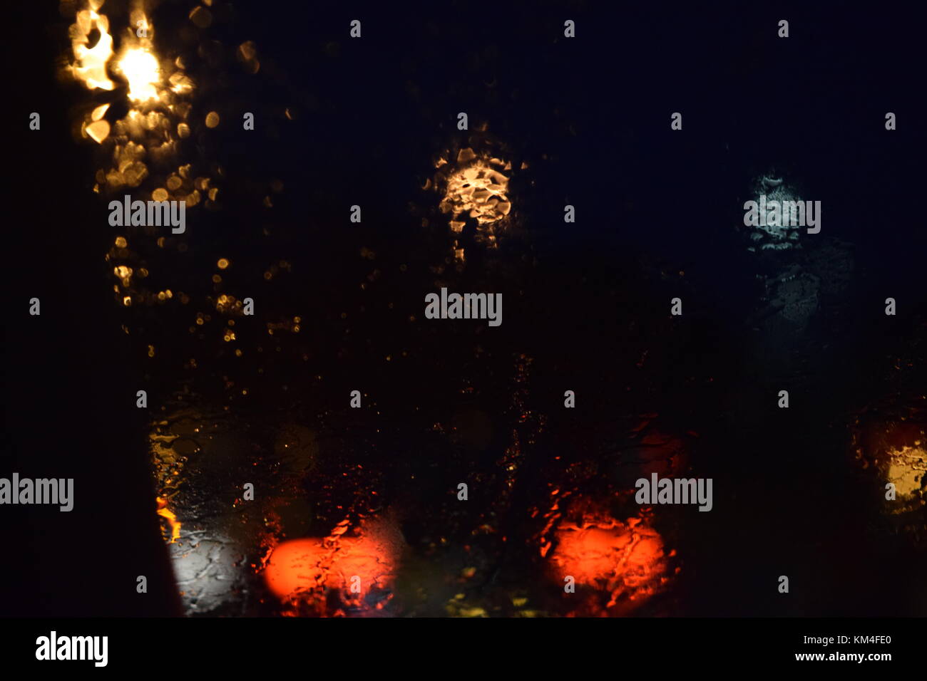 Street lights captured through a rain covered window with the focus ...