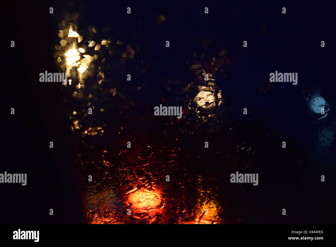 Street lights captured through a rain covered window with the focus ...