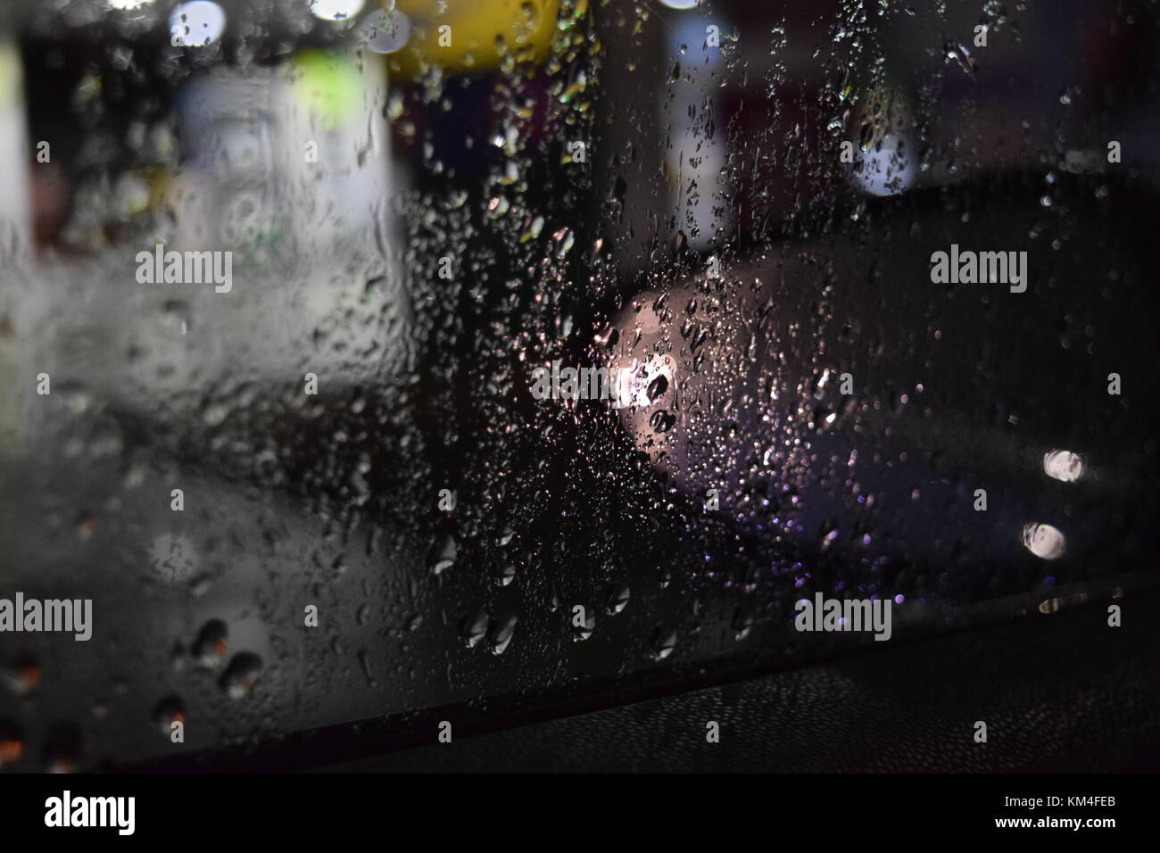 Street lights captured through a rain covered window with the focus ...