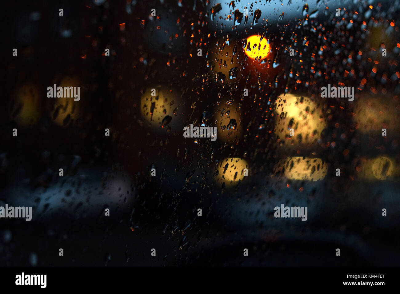 Street lights captured through a rain covered window with the focus ...