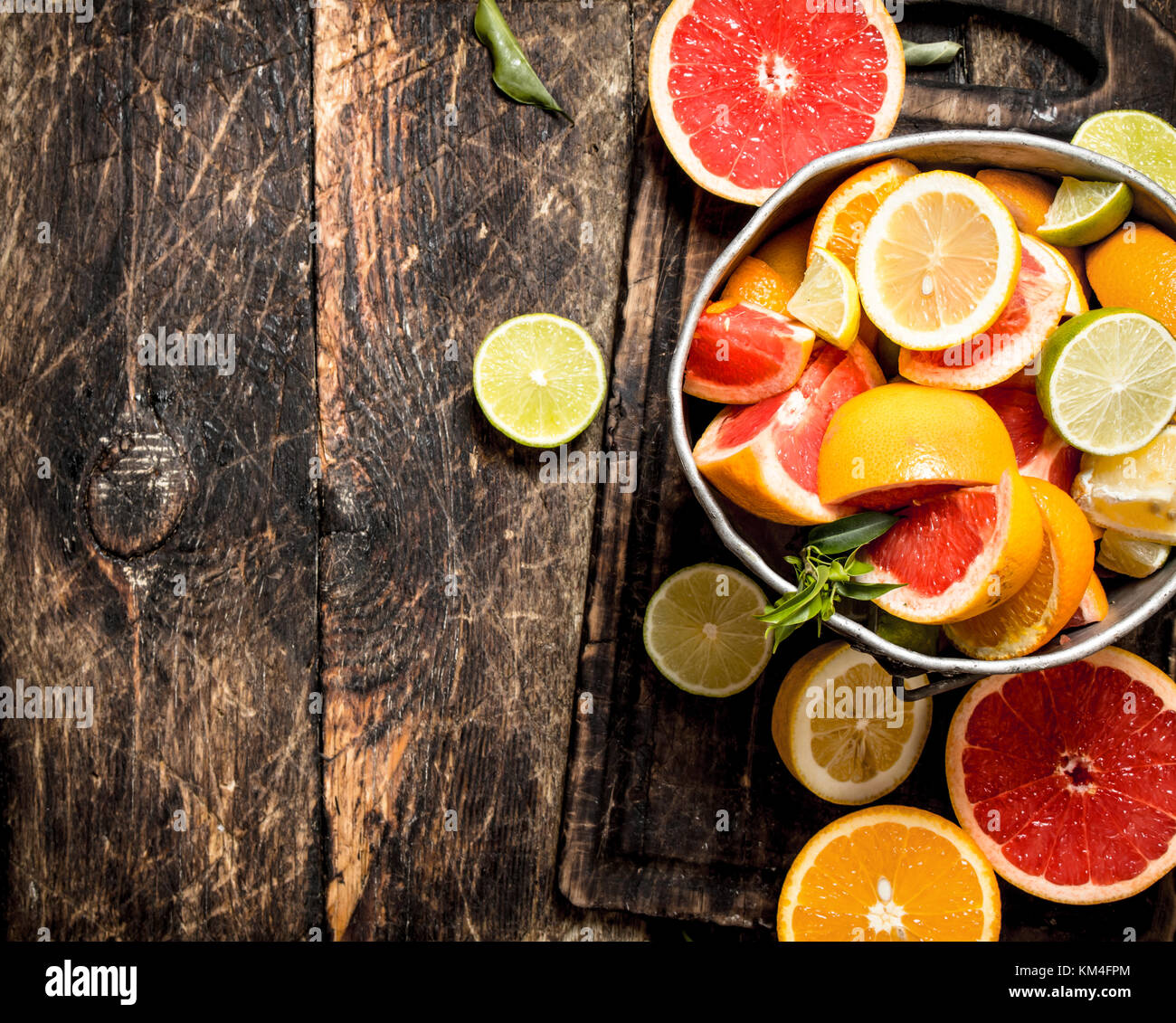 Citrus background. Fresh citrus fruits in the old bucket.On wooden ...