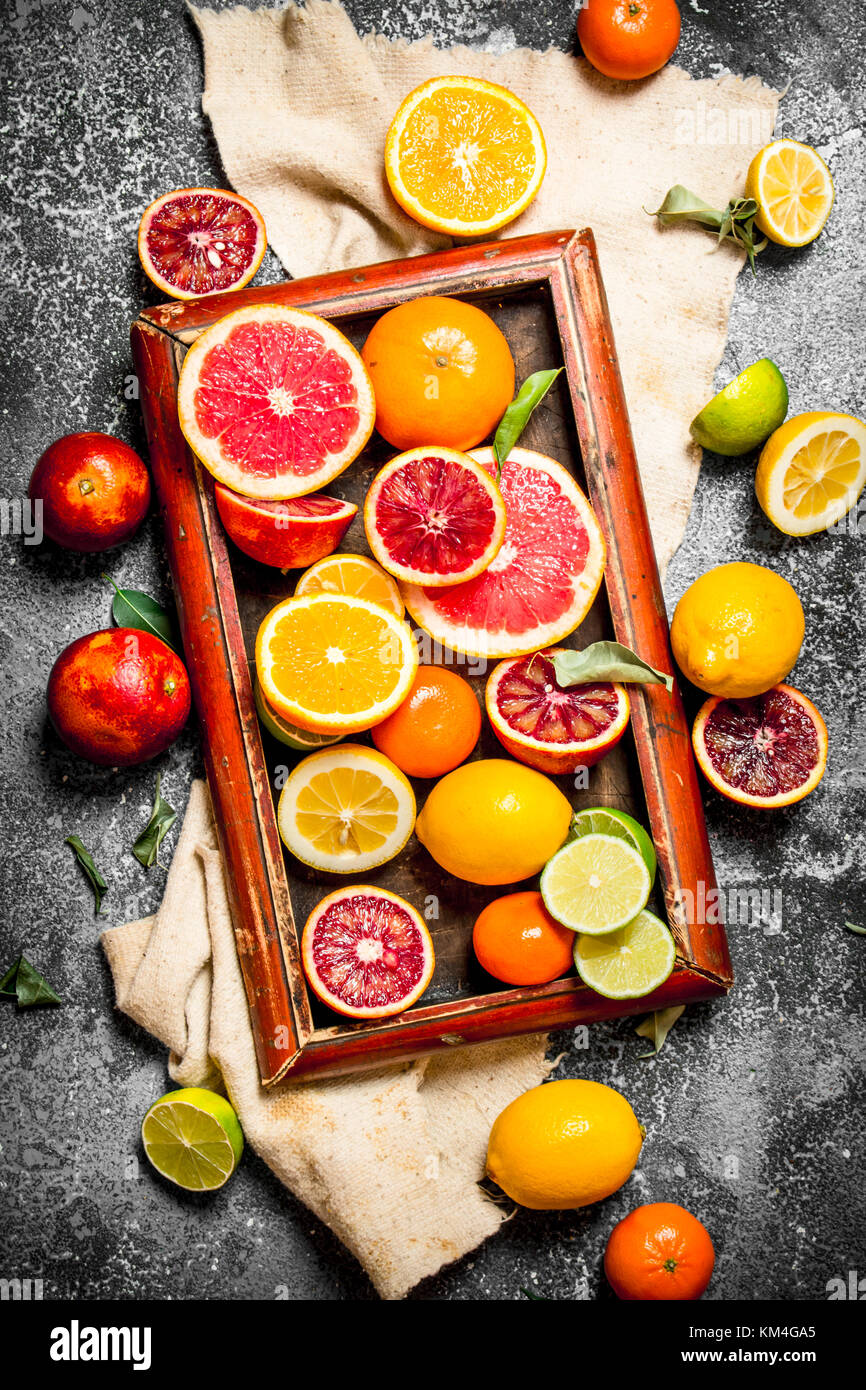Citrus background. Citrus fruits in the old tray. On rustic background ...
