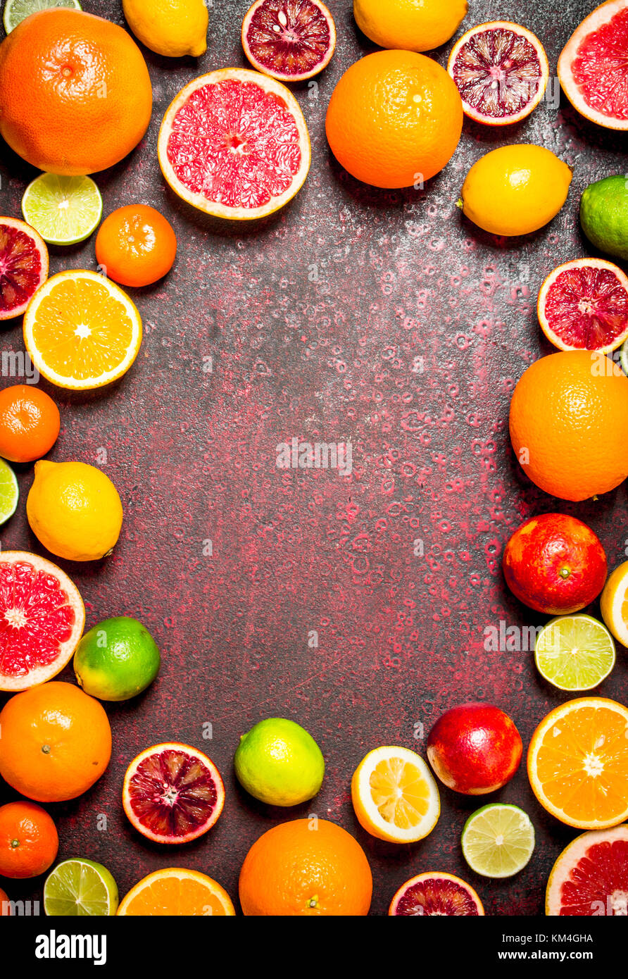 Citrus background. Citrus fruits . On rustic red background Stock Photo ...