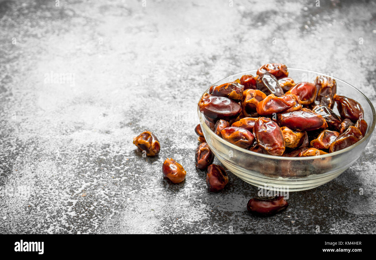 Dates in a bowl . On rustic background Stock Photo - Alamy