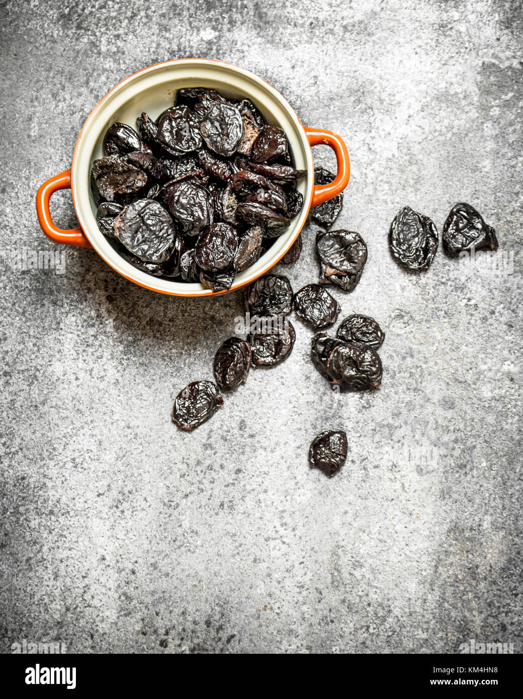Prunes in a bowl. On rustic background Stock Photo - Alamy