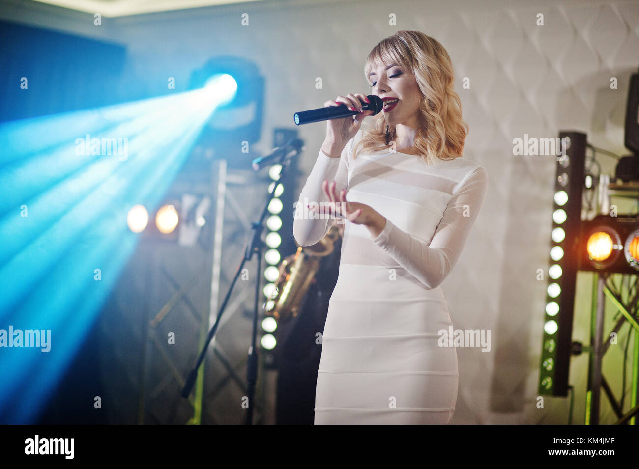 Beautiful blonde vocal singer girl on stage Stock Photo - Alamy