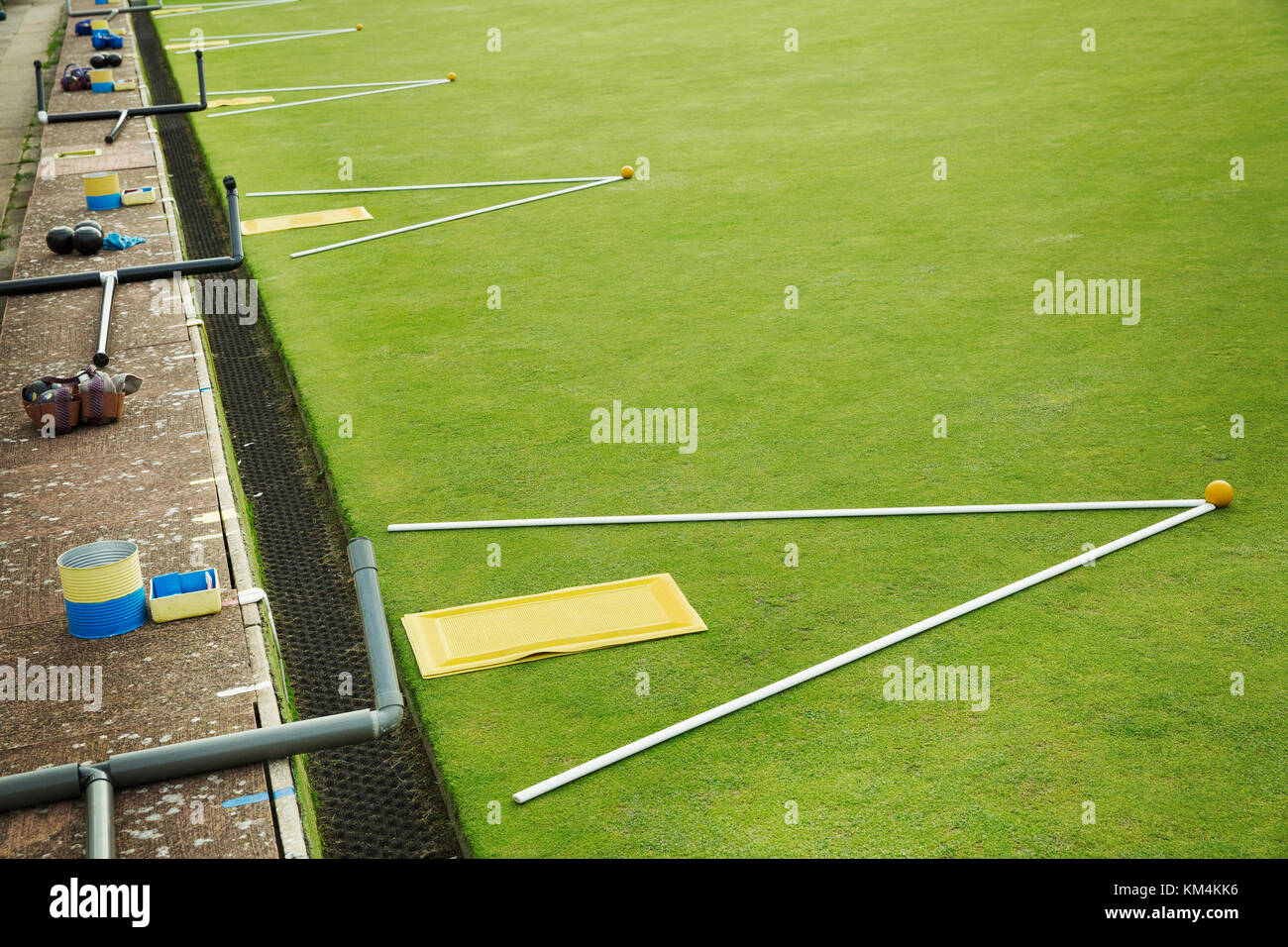 A lawn bowls green edge, a yellow player's mat to stand on and two ...
