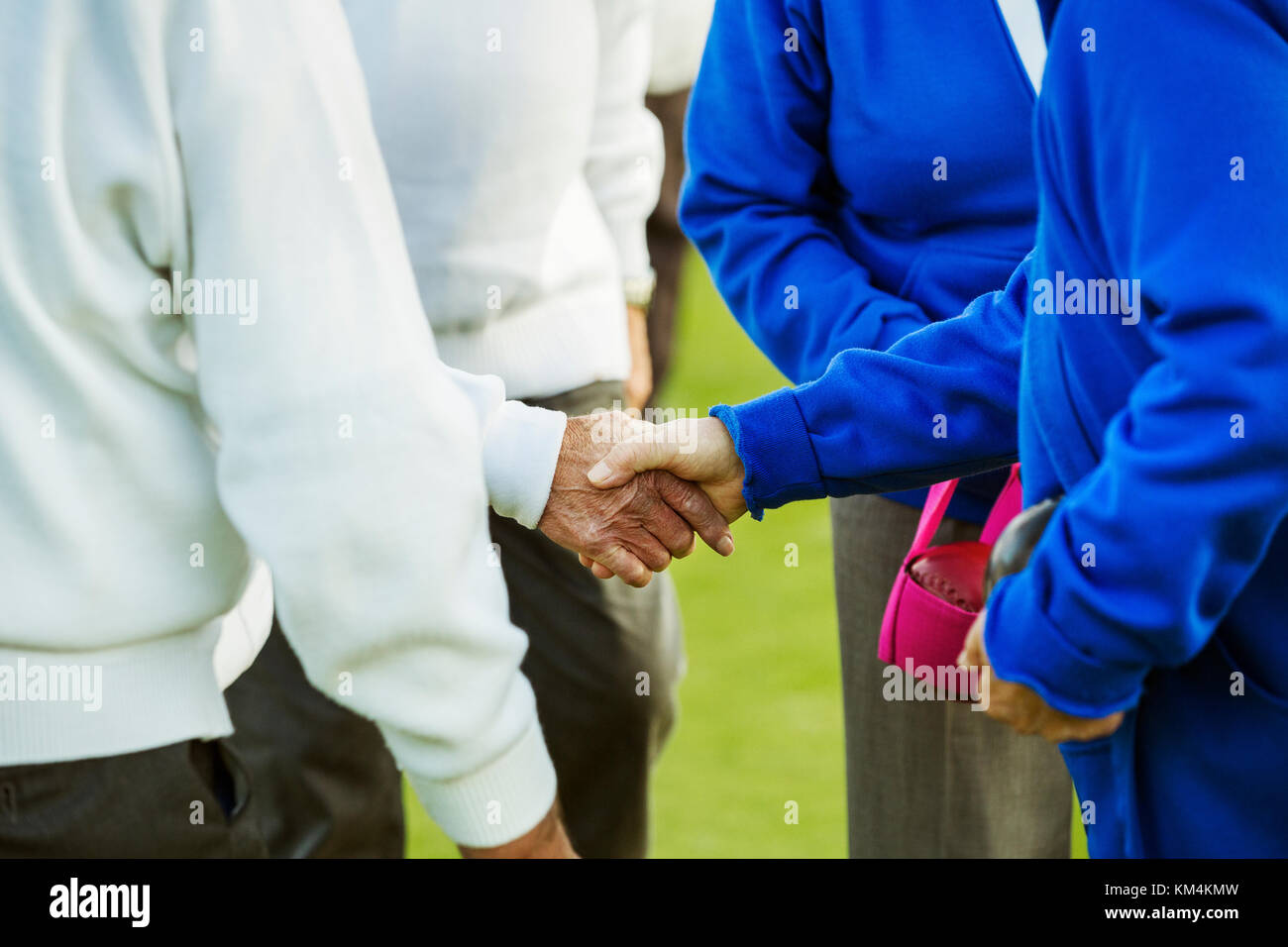 Two teams, four people shaking hands before or after a sporting match ...