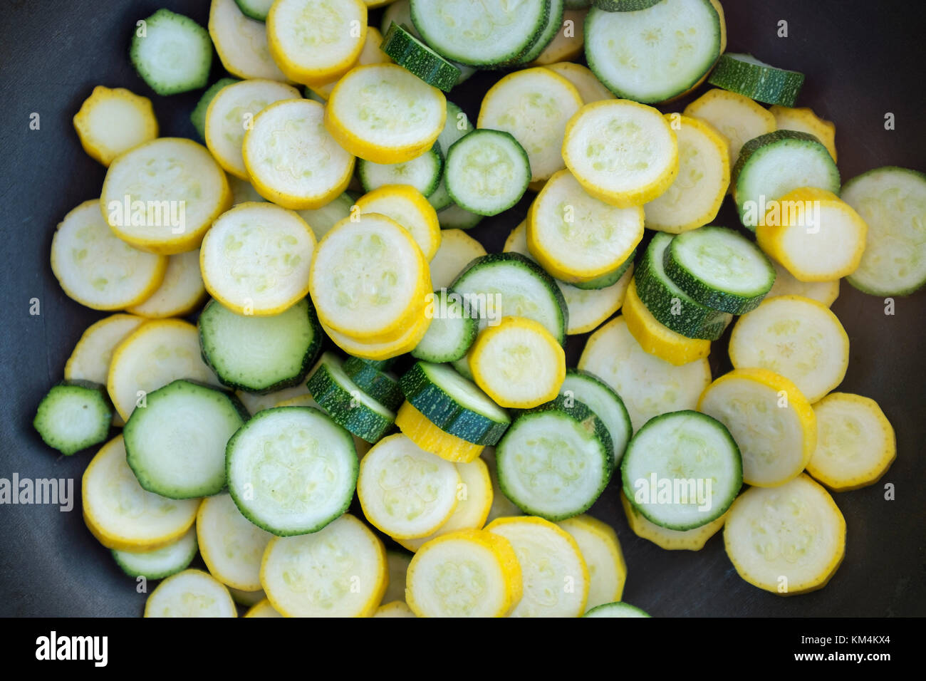 Sliced fresh zucchini courgette vegetables with green and yellow skins ...
