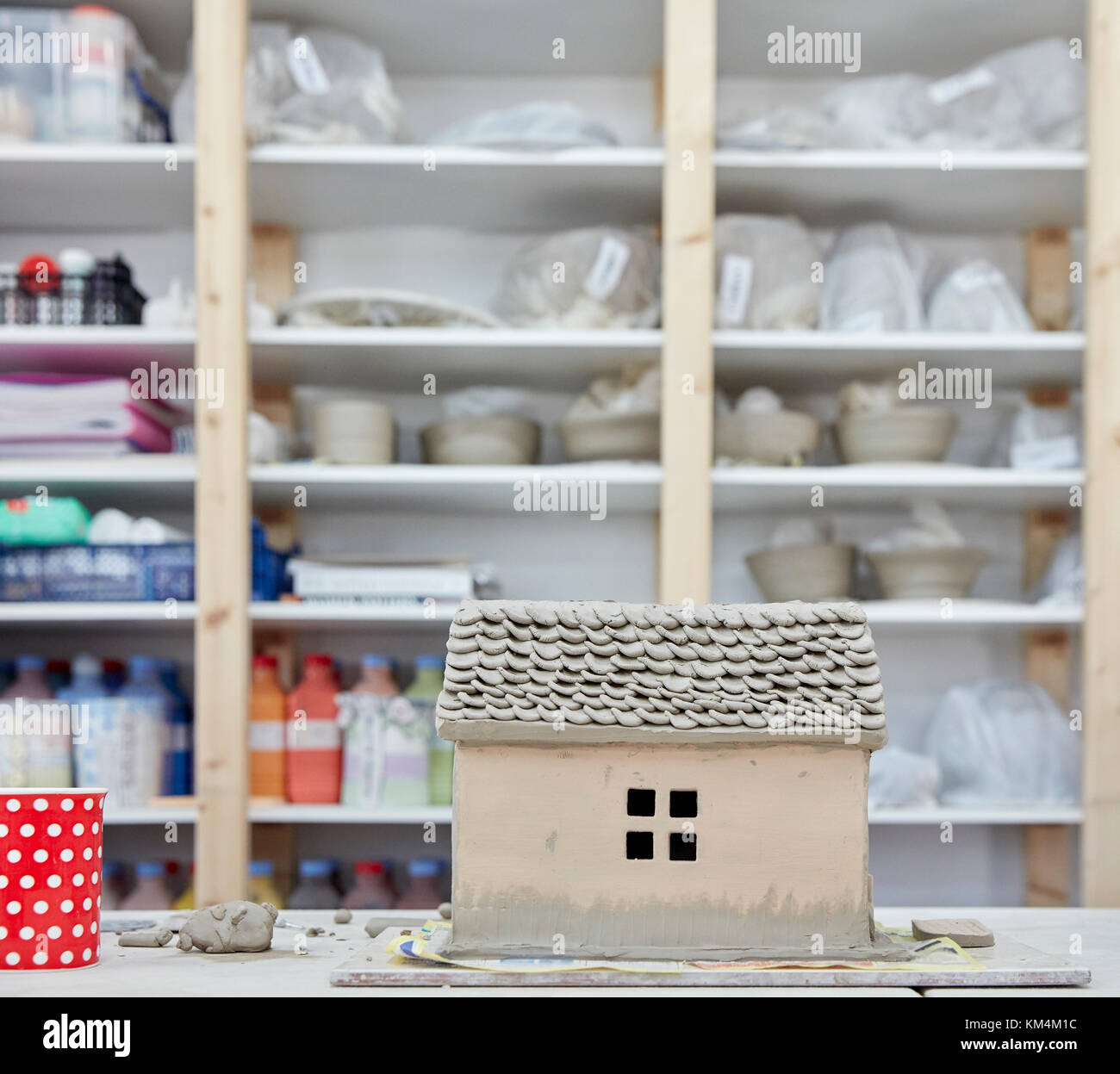 Shelves and pottery in a pottery studio, and a clay cottage on the ...