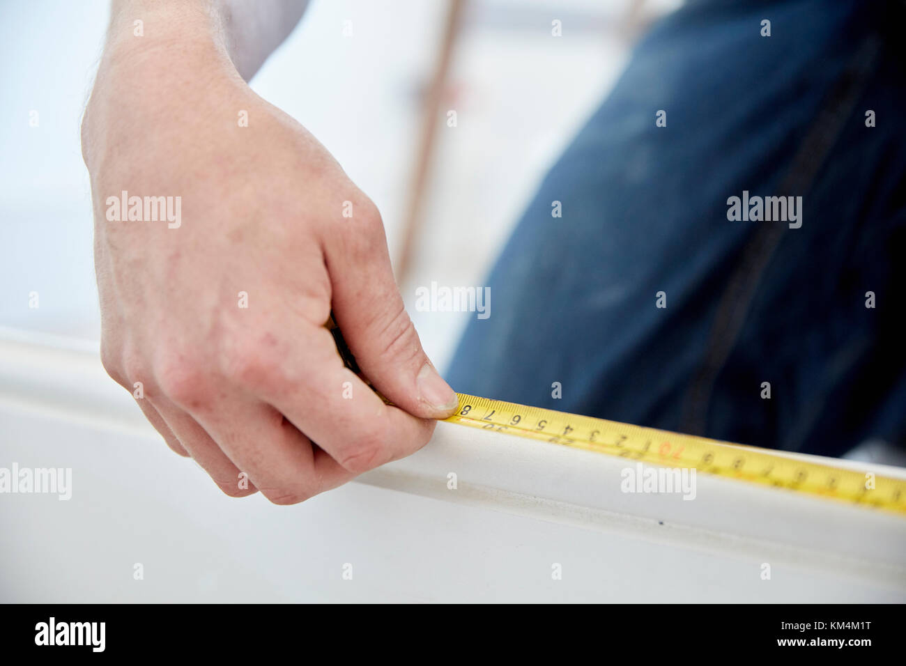 A man using a steel measuring tape Stock Photo - Alamy