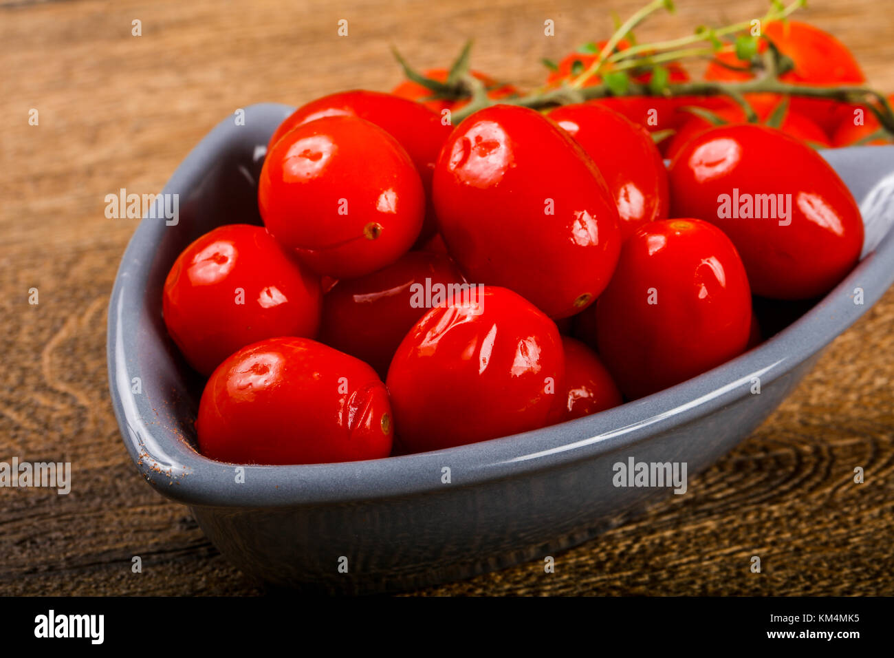 Pickled cherry tomatoes heap on the wooden background Stock Photo - Alamy