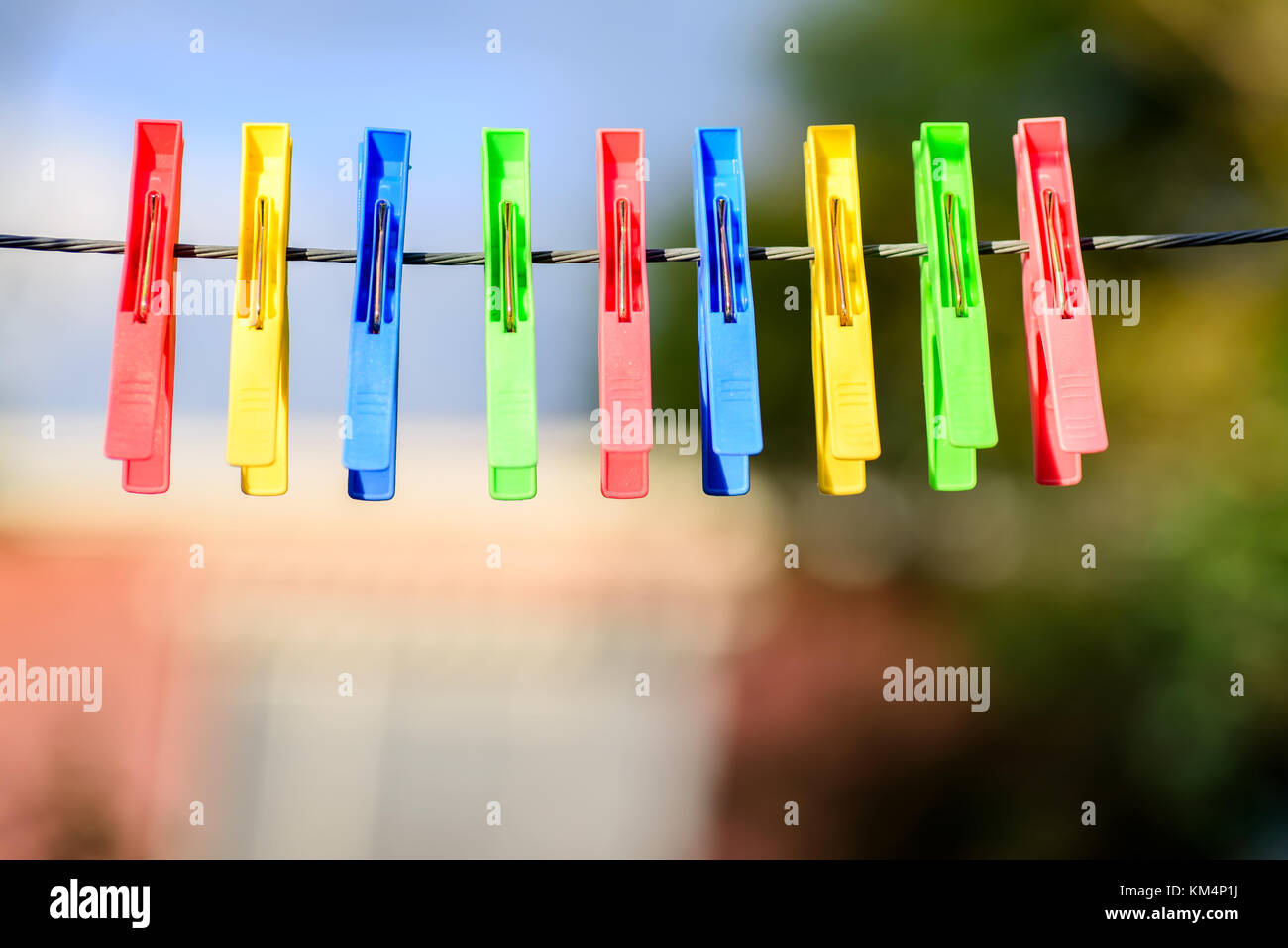 Colorful pegs hanging on clothesline Stock Photo - Alamy