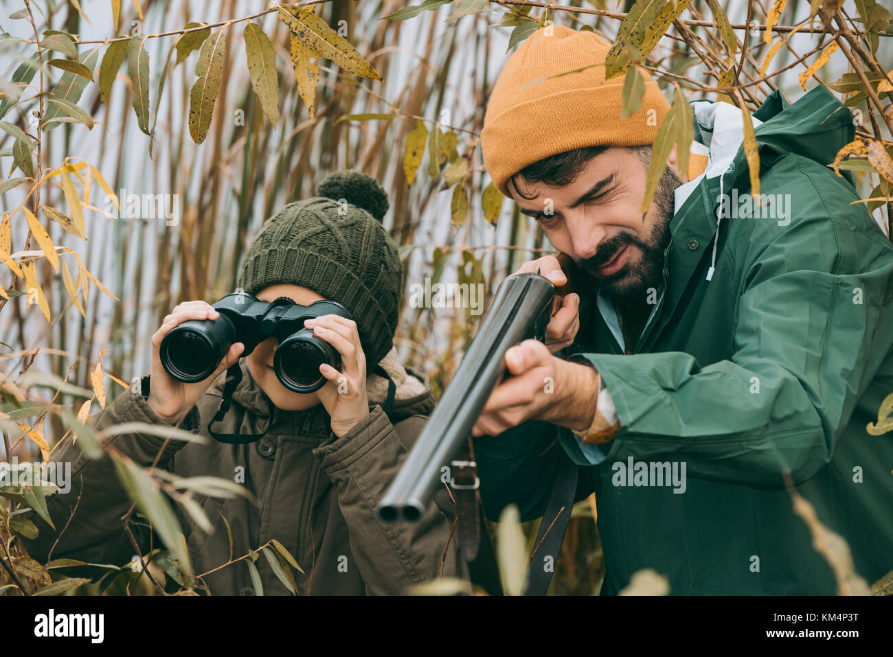 Father aiming at animal with gun Stock Photo - Alamy