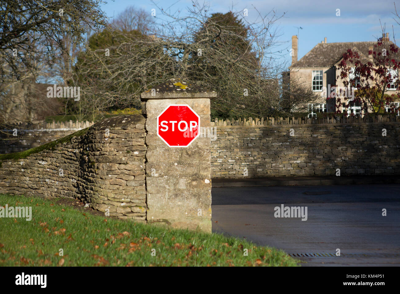 A large red and white stop sign on an old dry stone wall in the ...