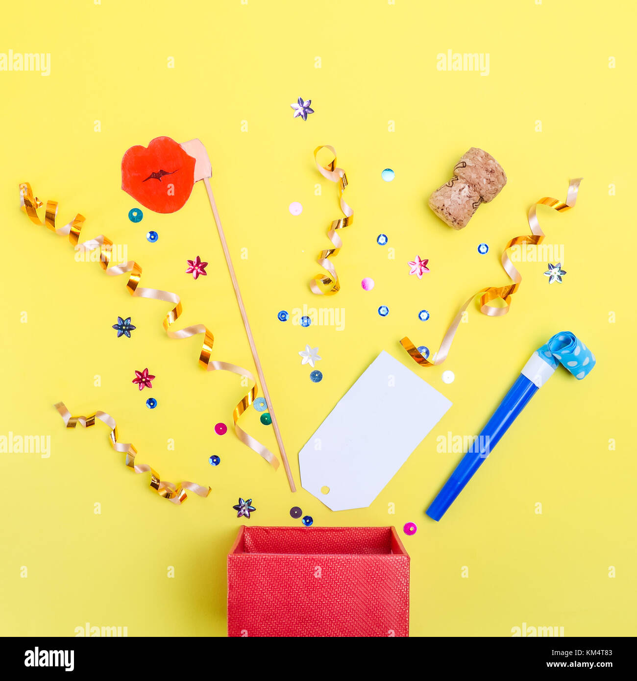 Box with splashed confetti of ribbon, glitters, sequins, dudes, cork ...