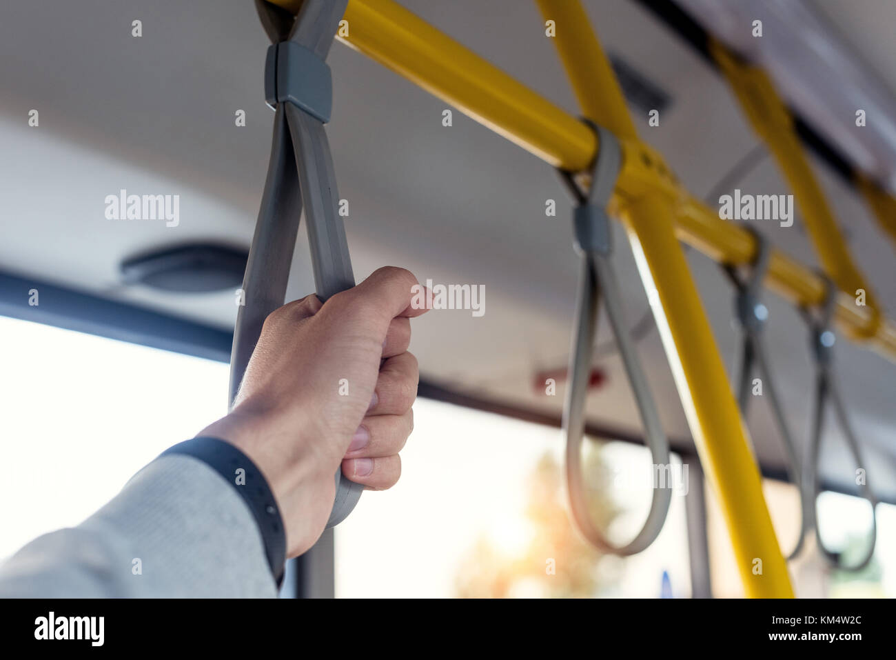 man holding bus handle Stock Photo - Alamy