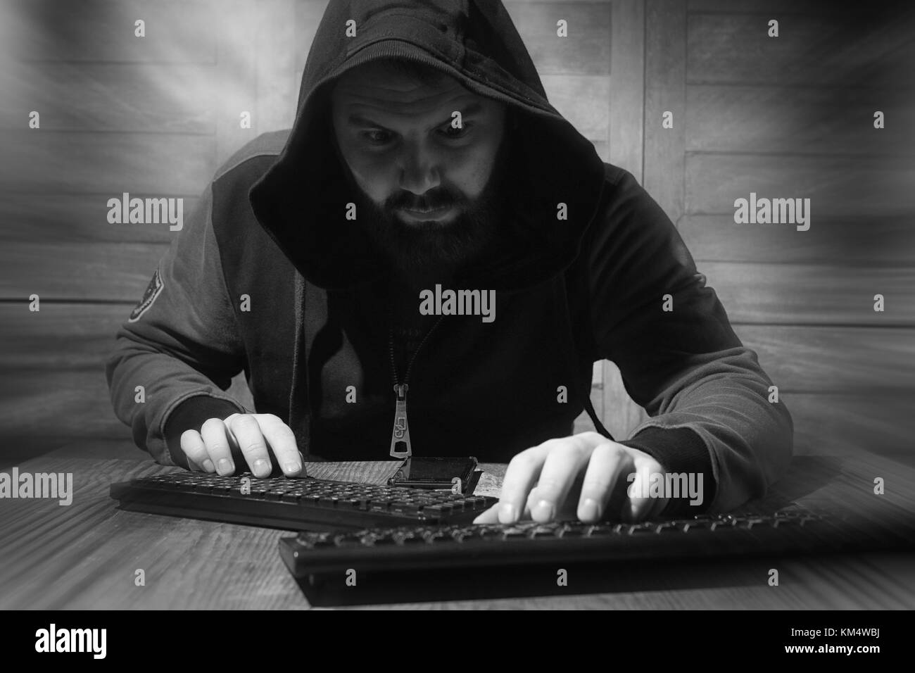 Hacker in black hood in Black and White Stock Photos & Images - Alamy