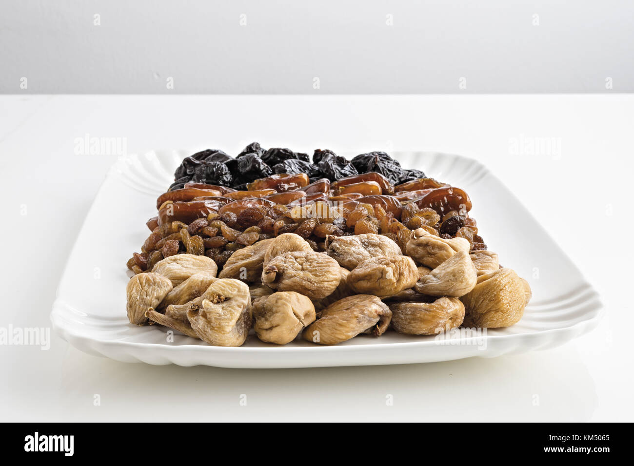 dates plums figs raisins trays 3 white background Stock Photo - Alamy