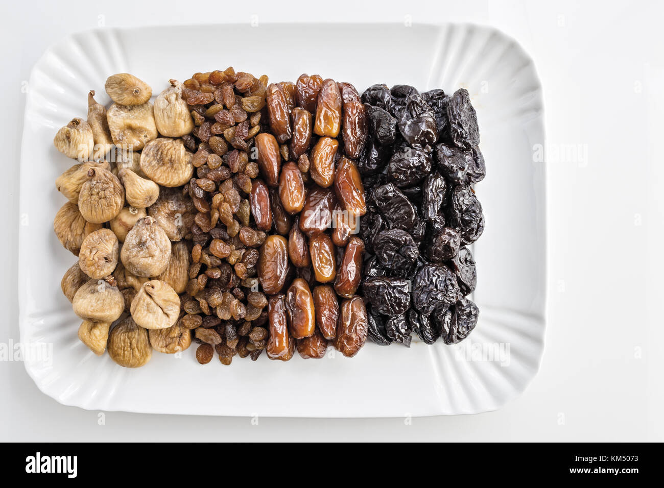 dates plums figs raisins trays 1 white background Stock Photo - Alamy