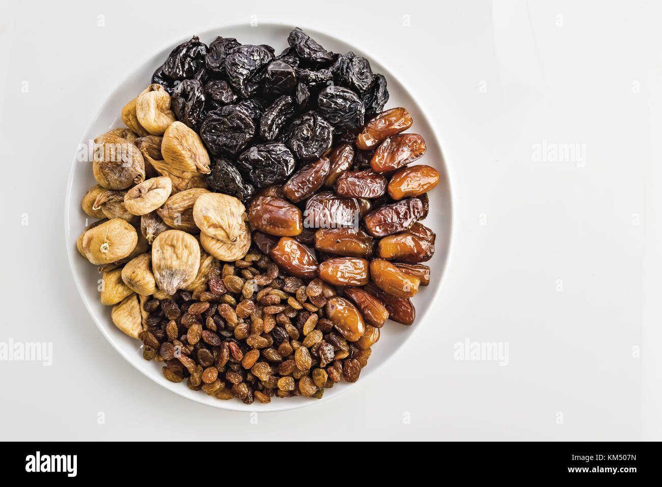 dates plums figs raisins round dish 5 white background Stock Photo - Alamy