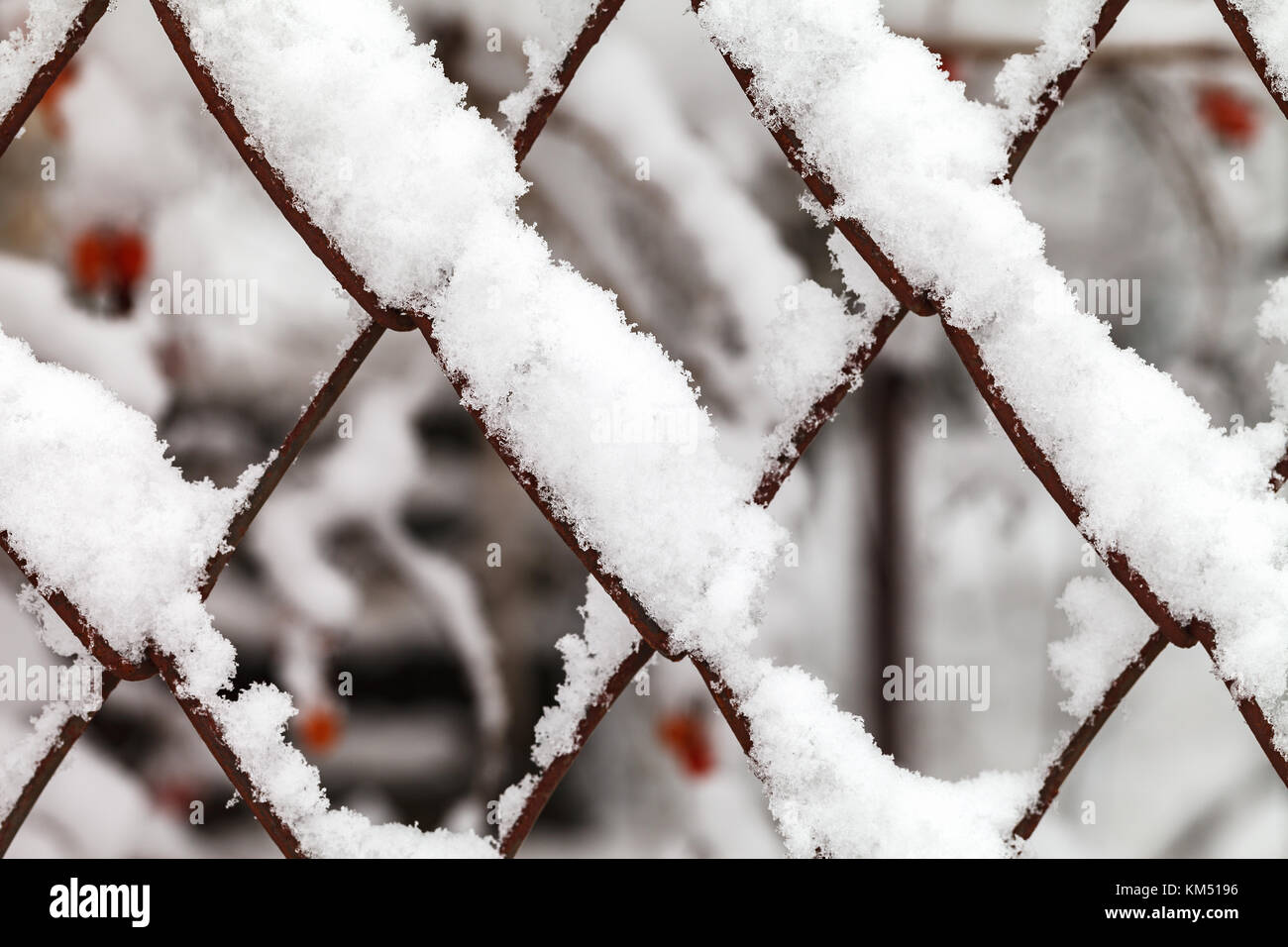 The grid of metal slabs is covered with snow. Beautiful pattern and ...