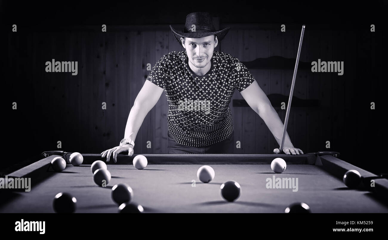 A man with a beard plays a big billiard. Party in a 12-foot pool Stock ...